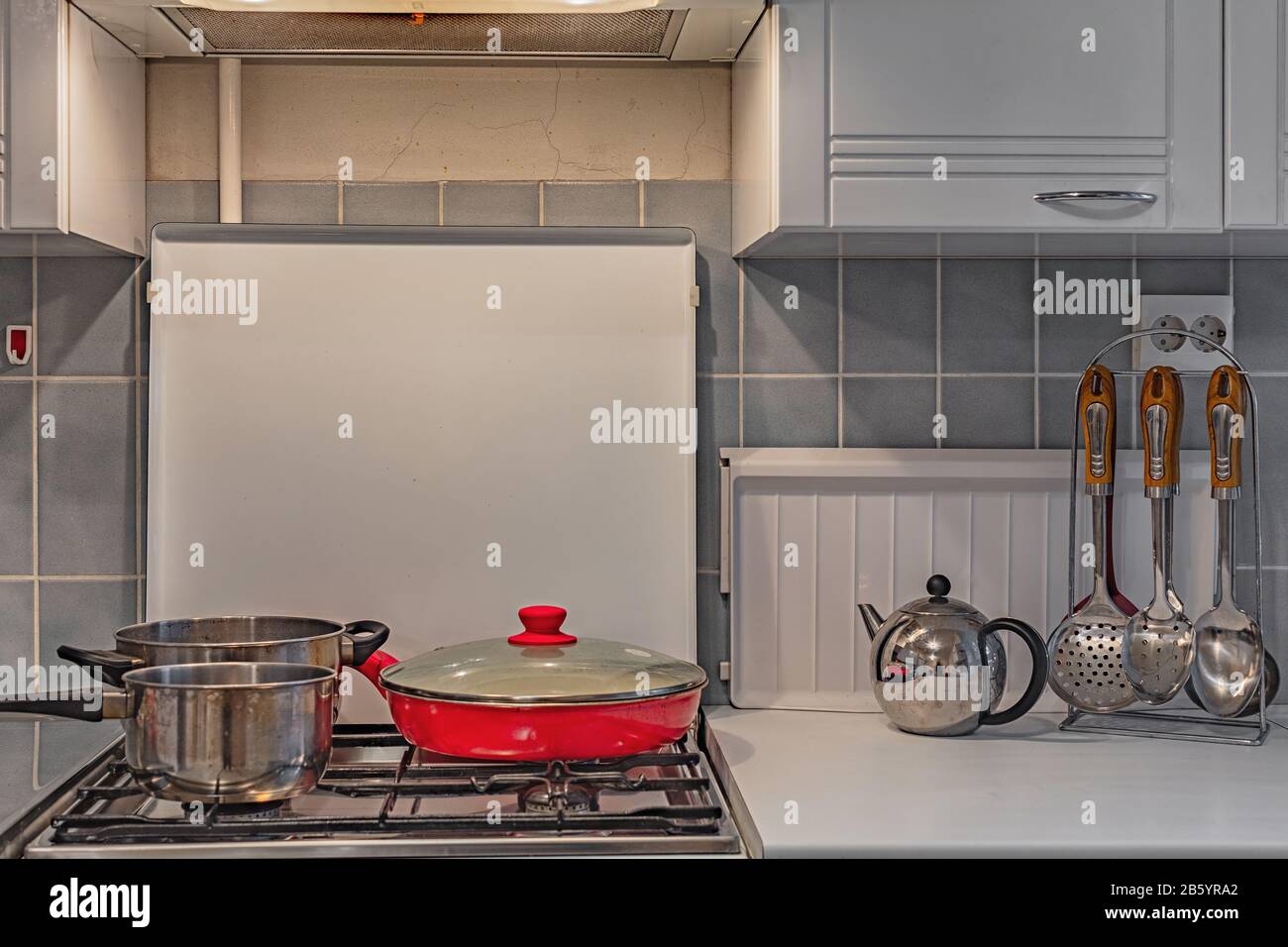 Everyday cooking set of utensil on gas stove with extractor closeup in ...