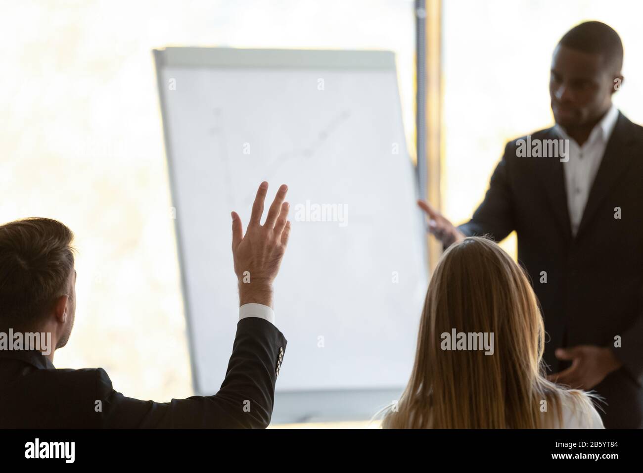 Close up rear back view young businessman raising hand Stock Photo - Alamy