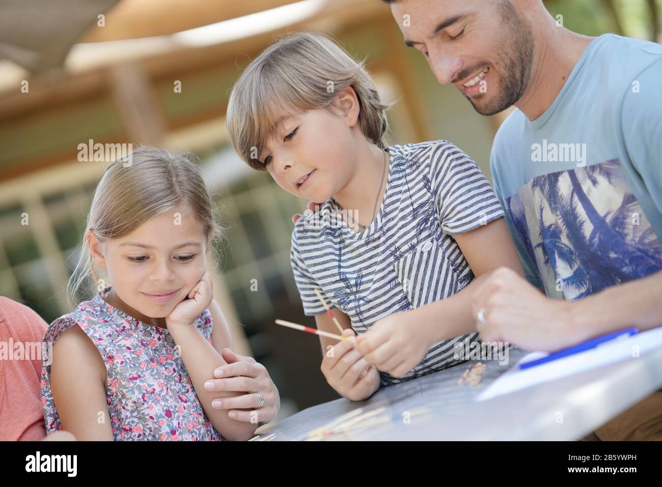 Happy family enjoying playing game together Stock Photo - Alamy