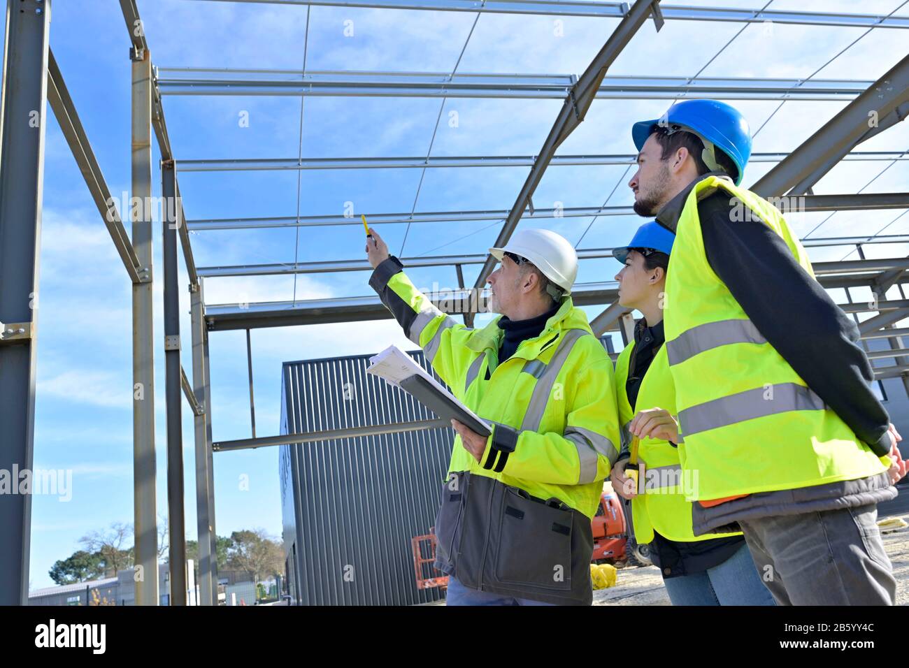 Engineering instructor working on building site with apprentice Stock ...