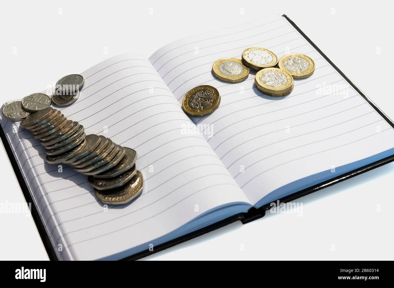 coins on notebook on white background.finance concept Stock Photo - Alamy