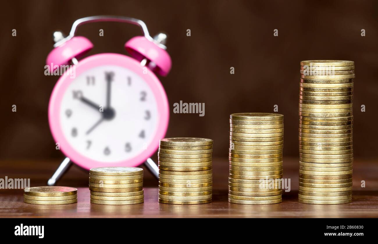 Financial freedom concept. Gold money coins stack with pink alarm clock ...