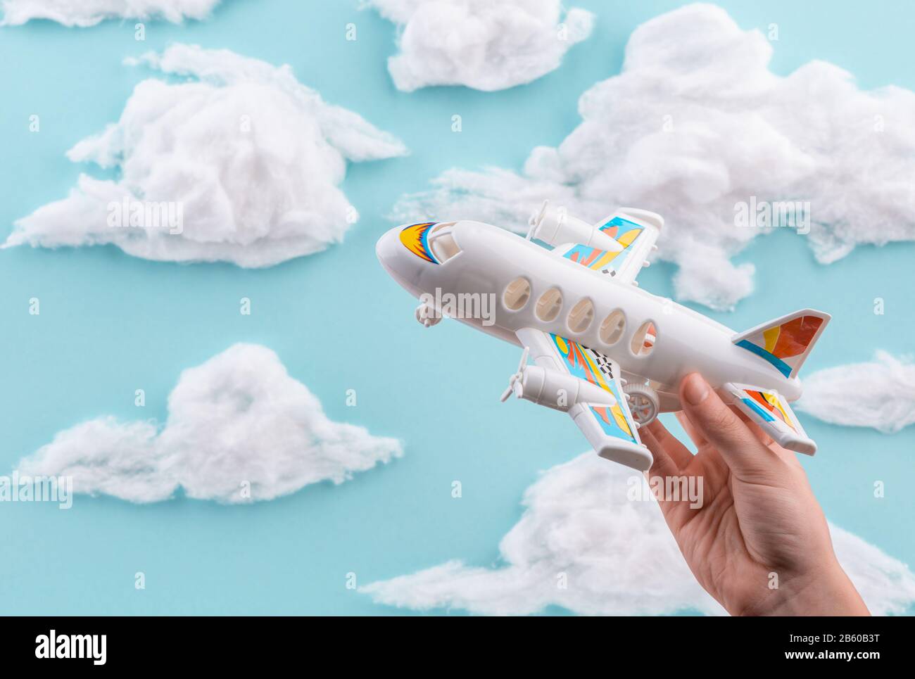 White airplane toy in child's hand flying through handmade sky Stock ...