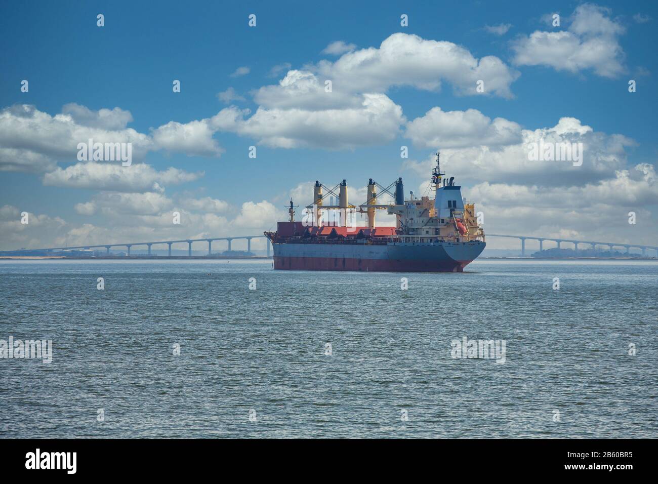 A dredging ship anchored in a harbor and working on the shipping lane ...
