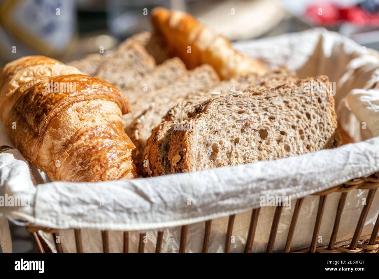 Sliced black integral bread and croissant in a basket. Closeup Stock ...