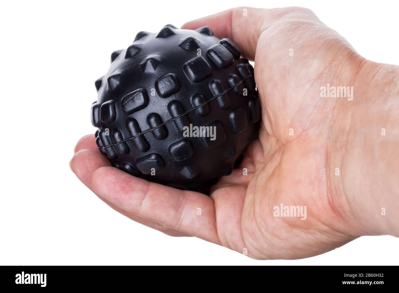 Hand holding a ball with spikes for myofascial massage. On a white ...