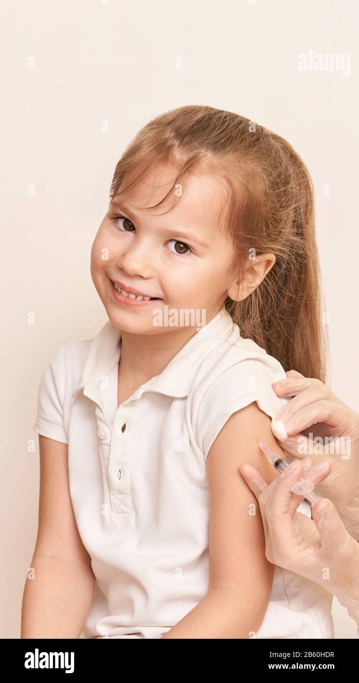 Doctor do injection to young girl. Kid immunization Stock Photo - Alamy