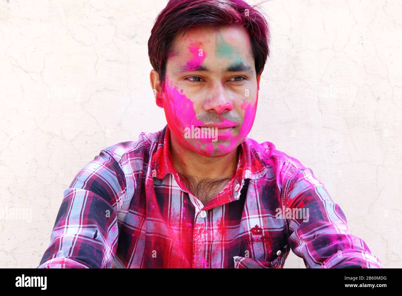 Closeup shot of Indian young man covered with multi color dry paint at ...