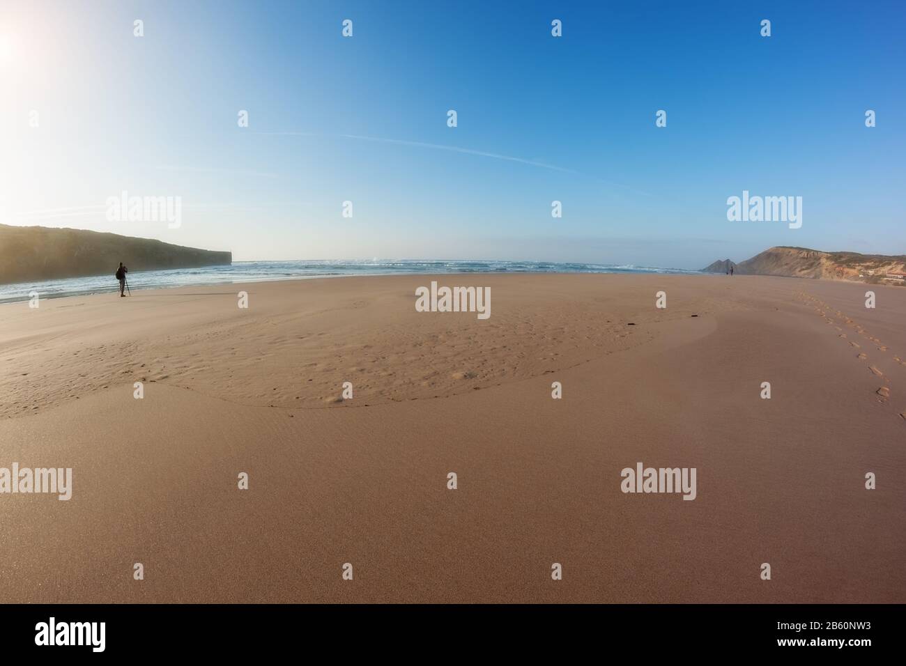 Panorama of a sandy beach and a photographer working in front of the ...