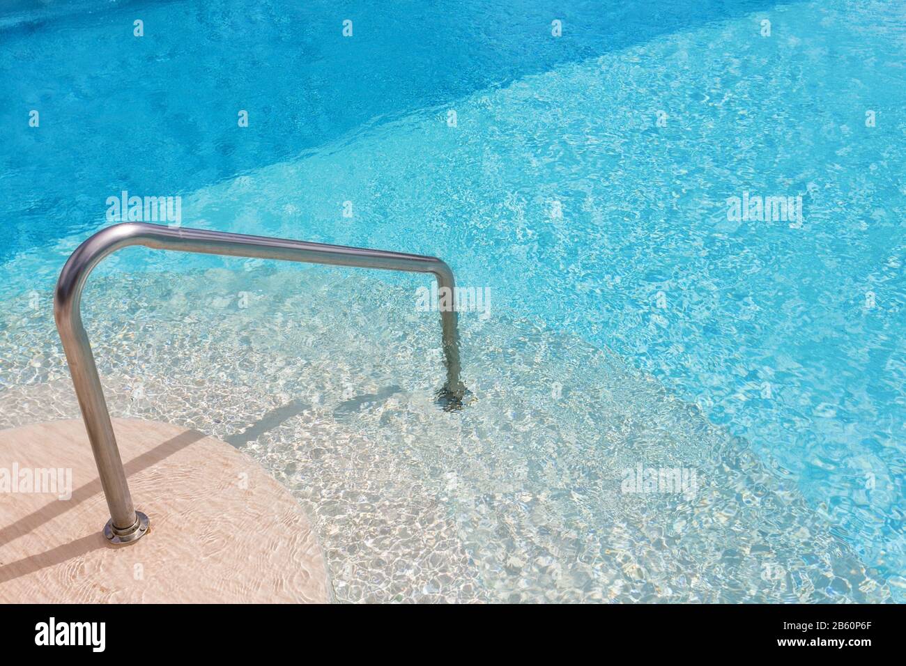 Calm swimming pool steps and handrail. In summer Stock Photo - Alamy