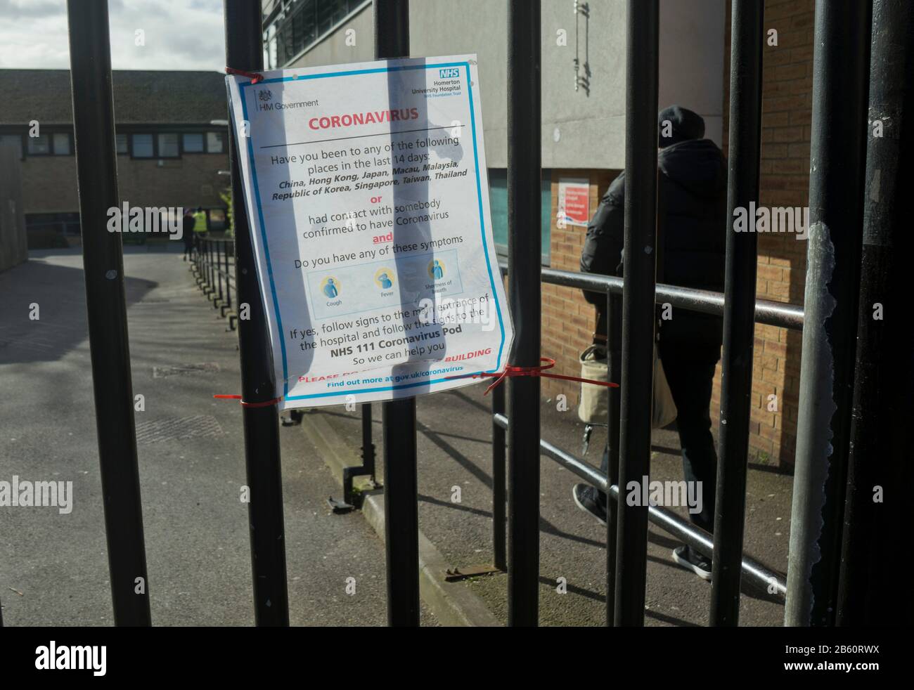 Visitors walk past Coronavirus warning signs at Homerton NHS hospital ...
