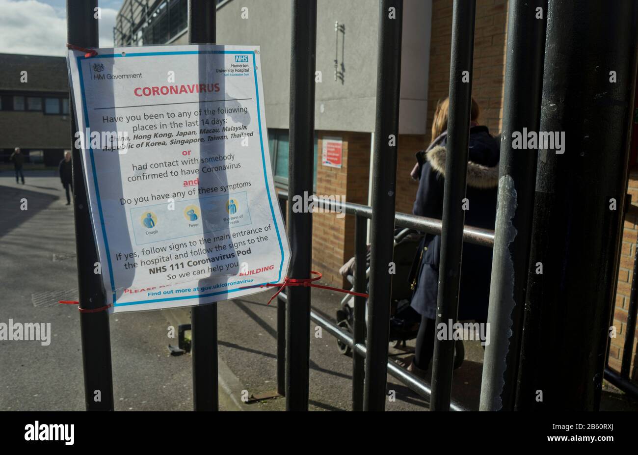Visitors walk past Coronavirus warning signs at Homerton NHS hospital ...