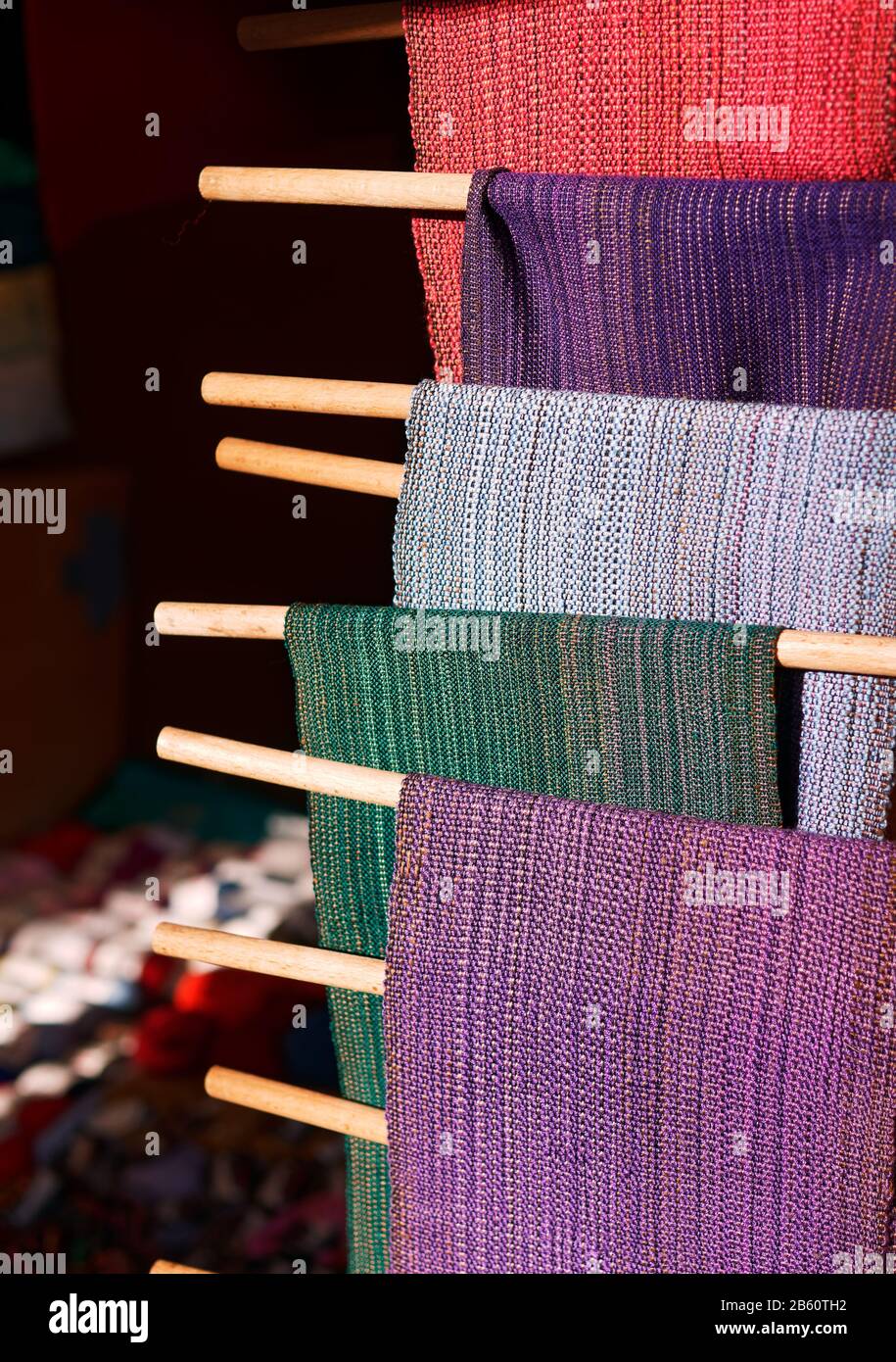 Colorful fabrics hanging at a market stall Stock Photo - Alamy