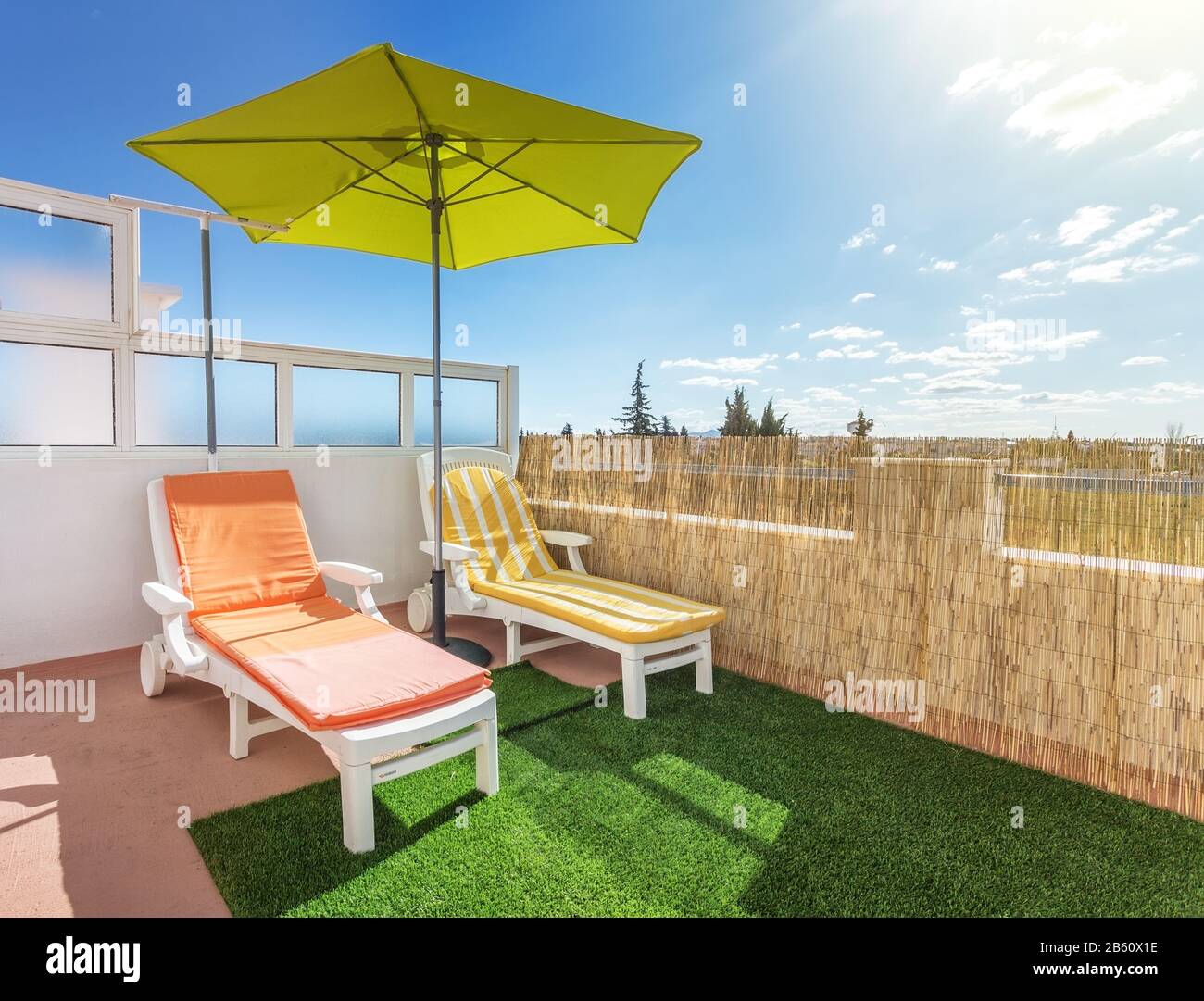 Umbrella and sunbed on the terrace for sunbathing and relaxing. Summer ...
