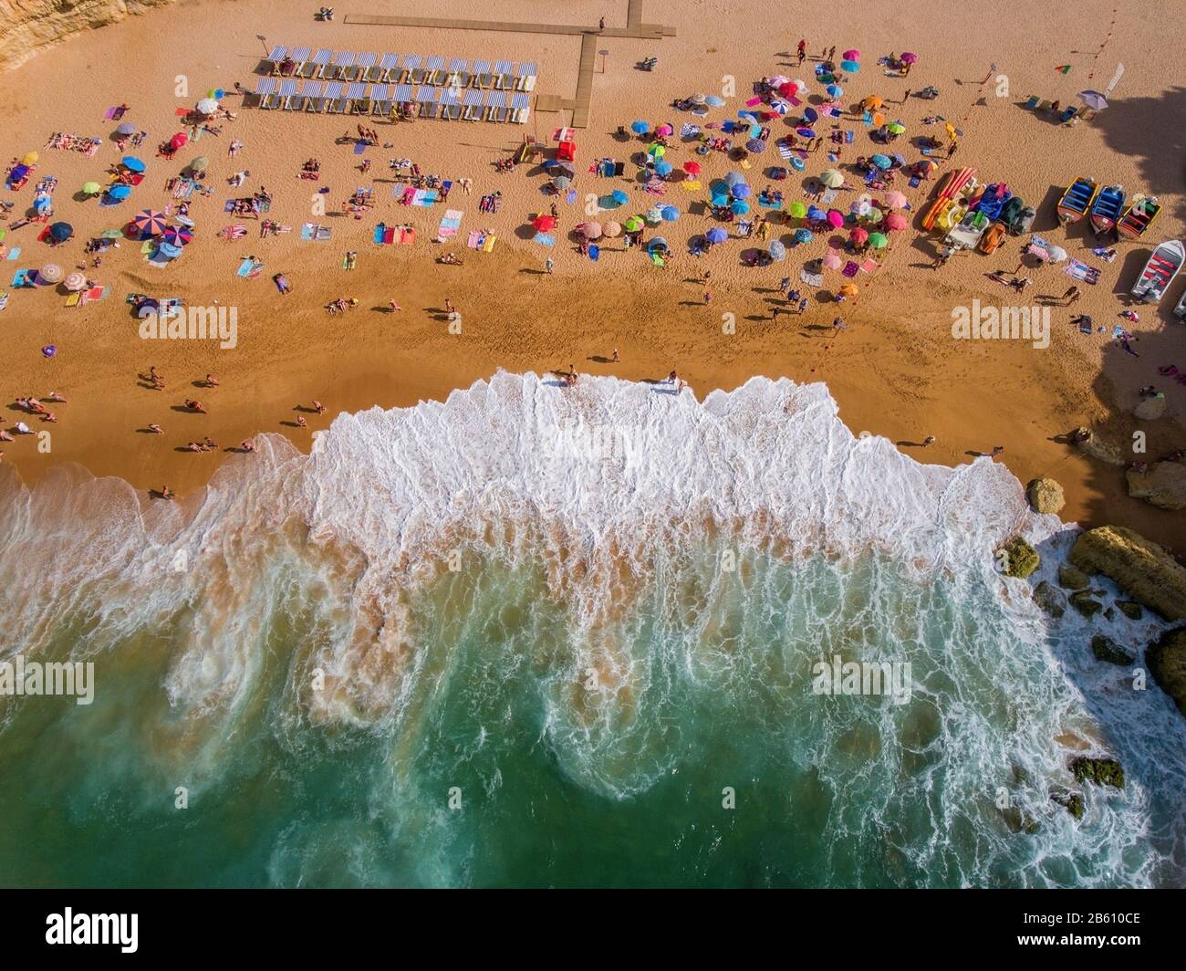 Roll forward waves on the beach with tourists. Aerial photo Stock Photo ...