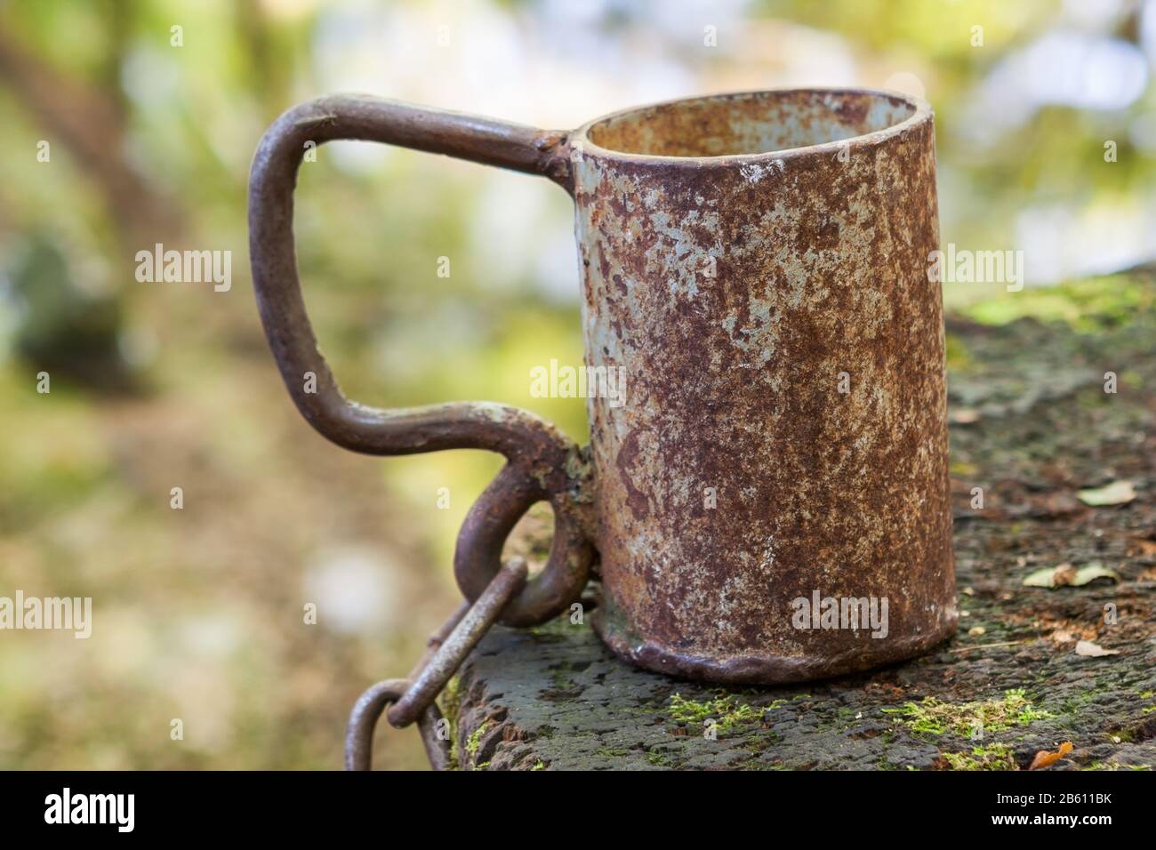 A metal mug for water with a chain near to a source Stock Photo - Alamy