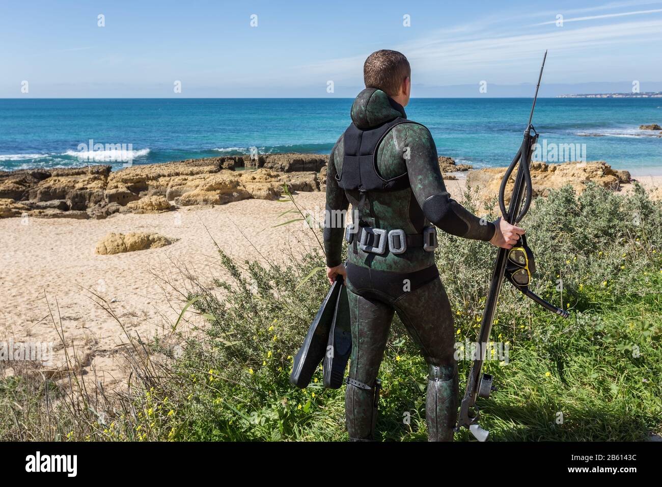 Underwater hunter with a gun in a mask. Looking at the sea Stock Photo ...