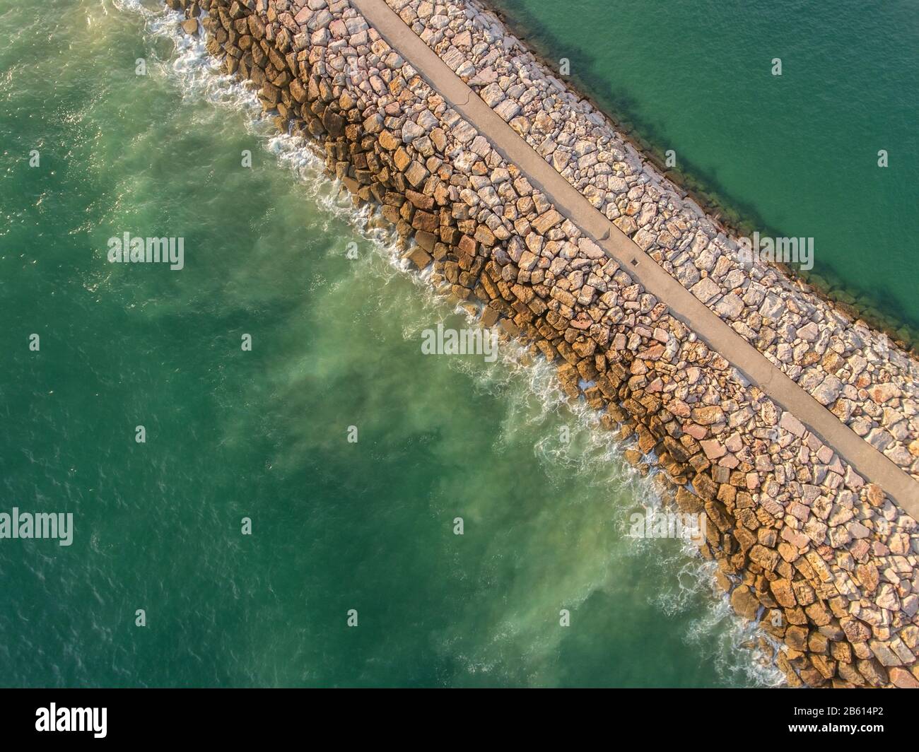 Aerial. Industrial breakwater, washed the waves in the sea. Filmed from ...