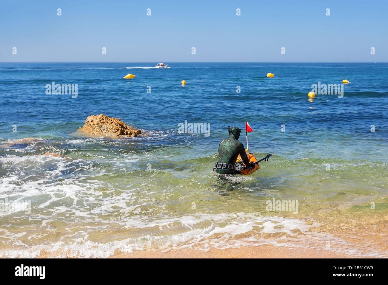 Underwater hunter in the water preparing to dive. Underwater fishing in ...