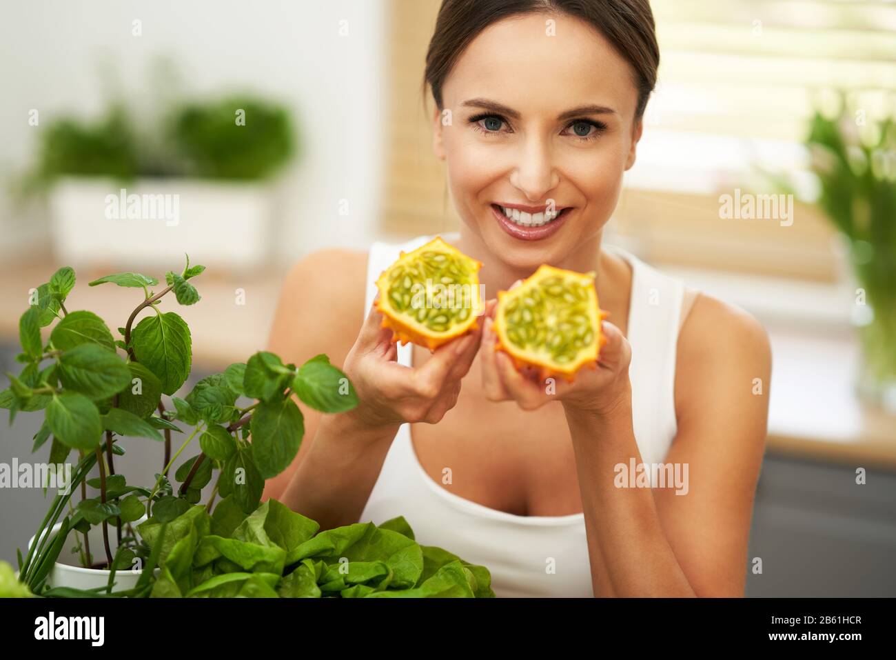 Healthy adult woman with green food in the kitchen Stock Photo - Alamy