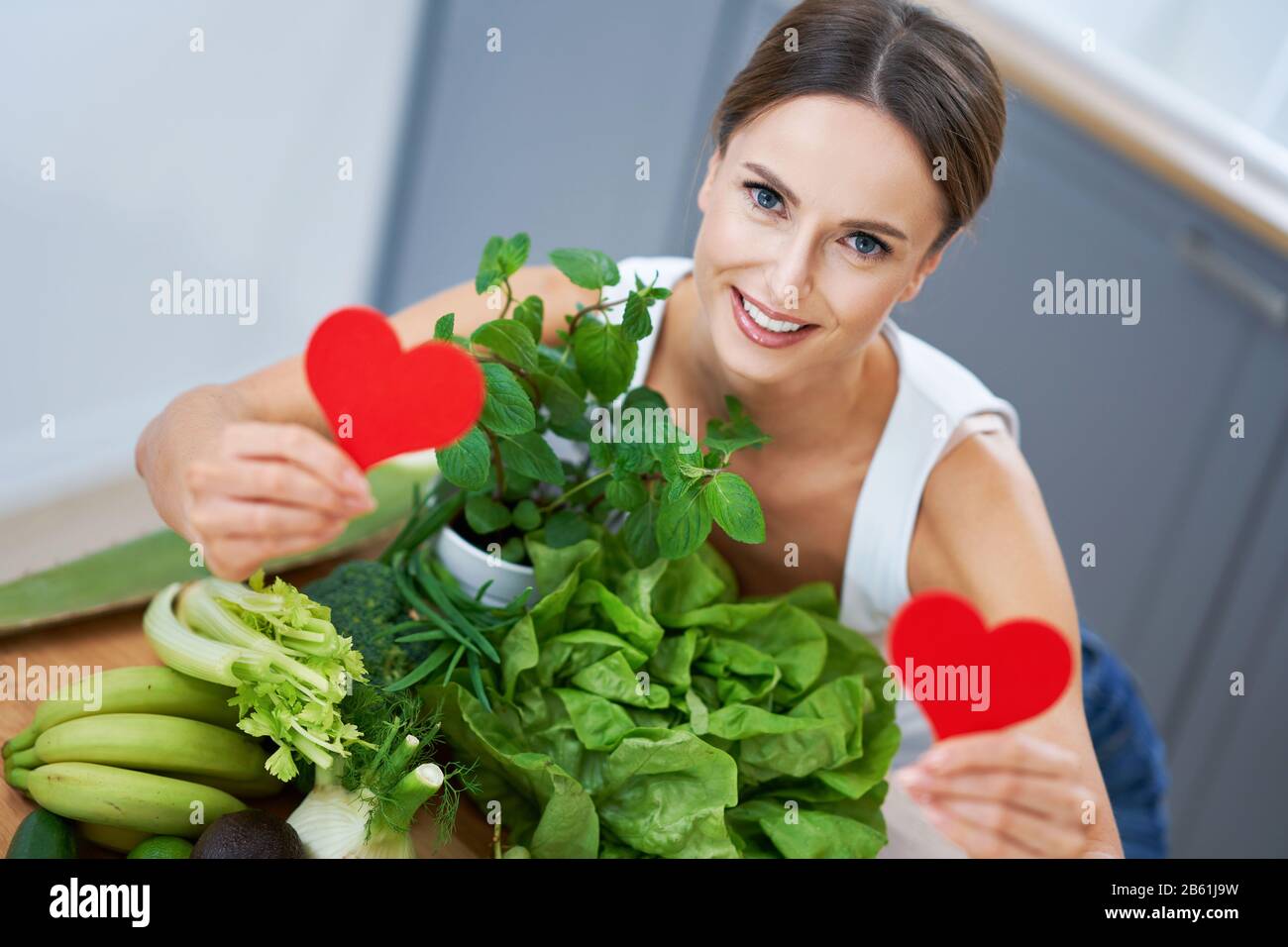 Healthy adult woman with green food in the kitchen Stock Photo - Alamy