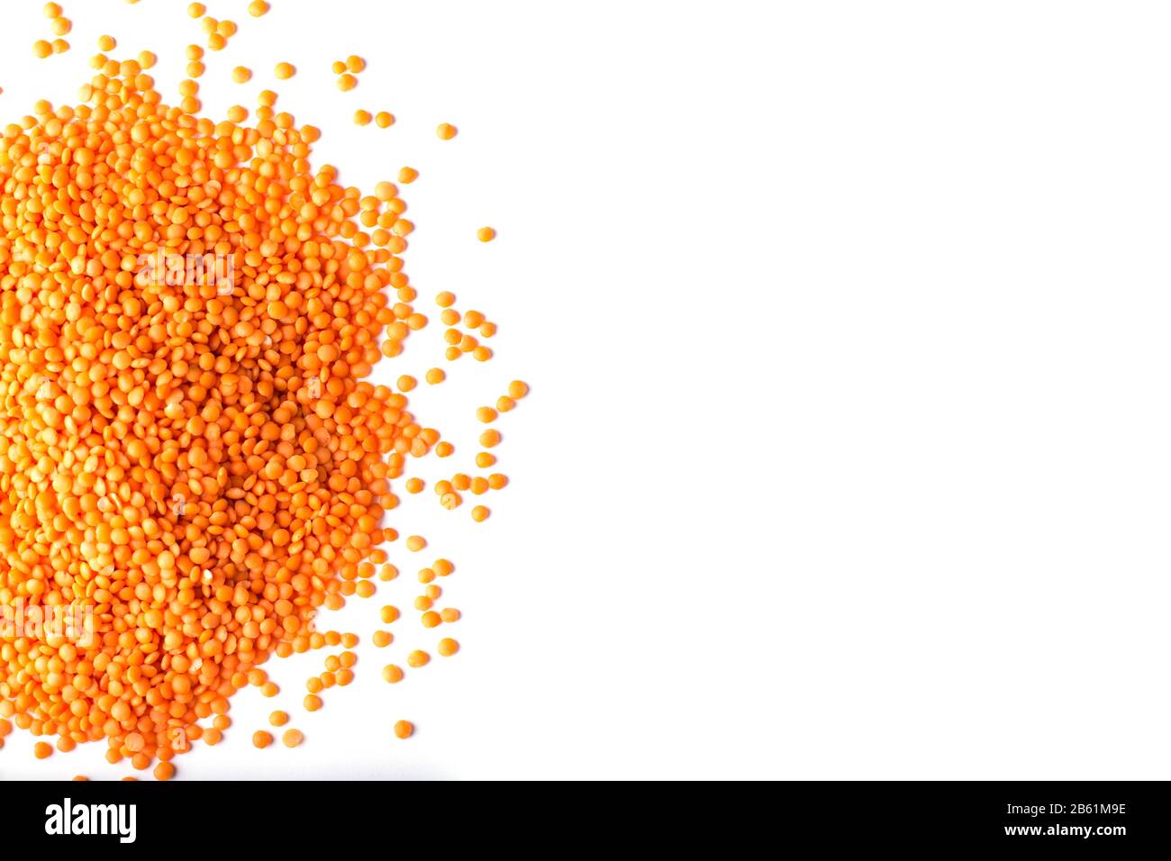orange lentil beans in a heap on a white background with copy space ...