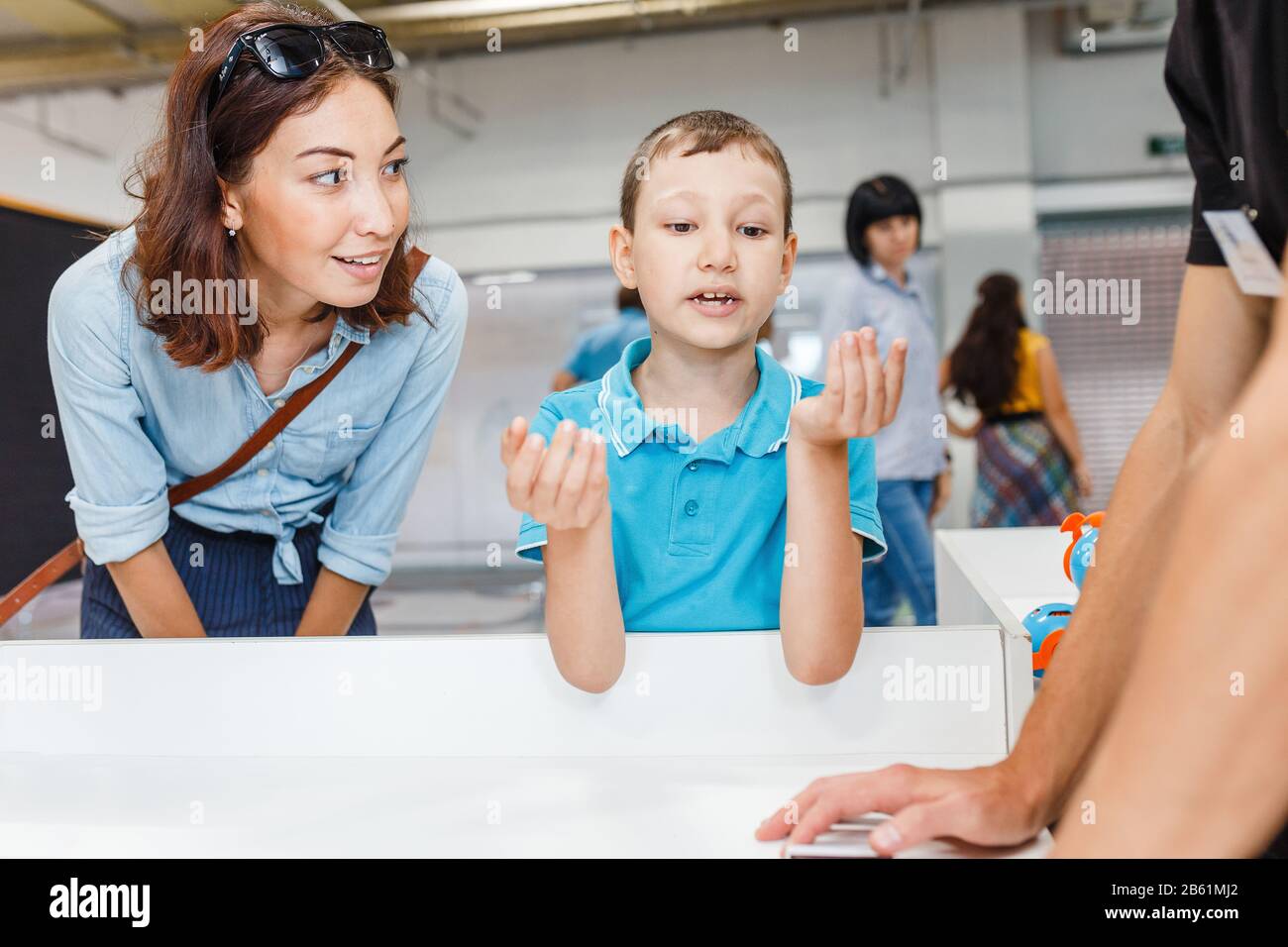 Child boy explain and gesticulate to his mother, education concept ...