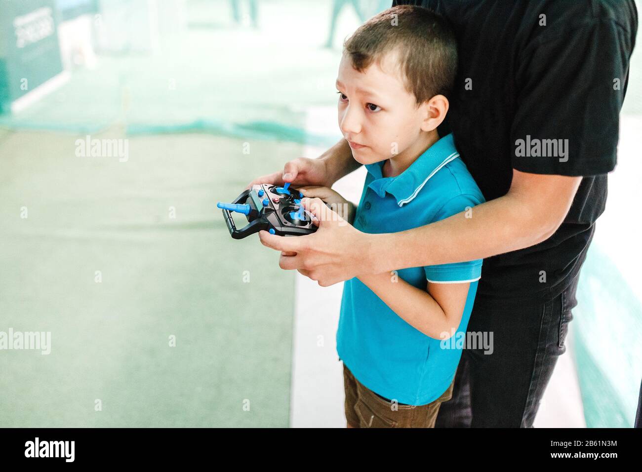 Adorable boy playing with wireless remote control with quadrocopter toy ...