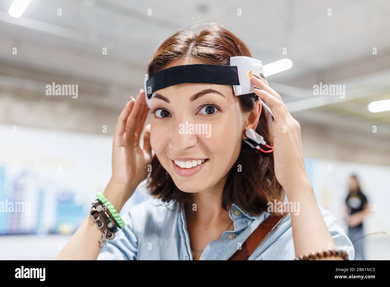 Woman with digital headset sensor connected to her ear, reading brain ...