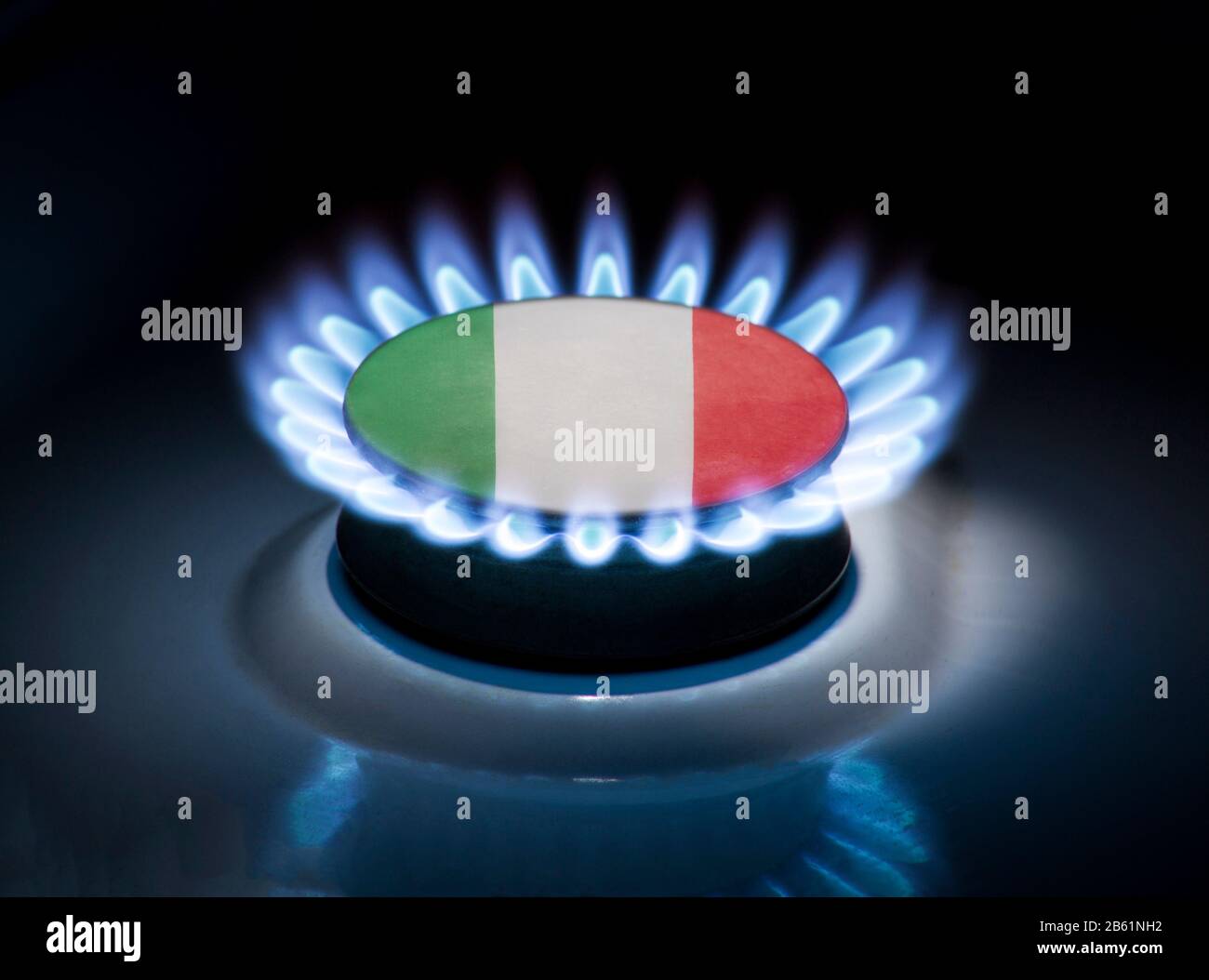 Burning gas burner of a home stove in the middle of which is the flag ...