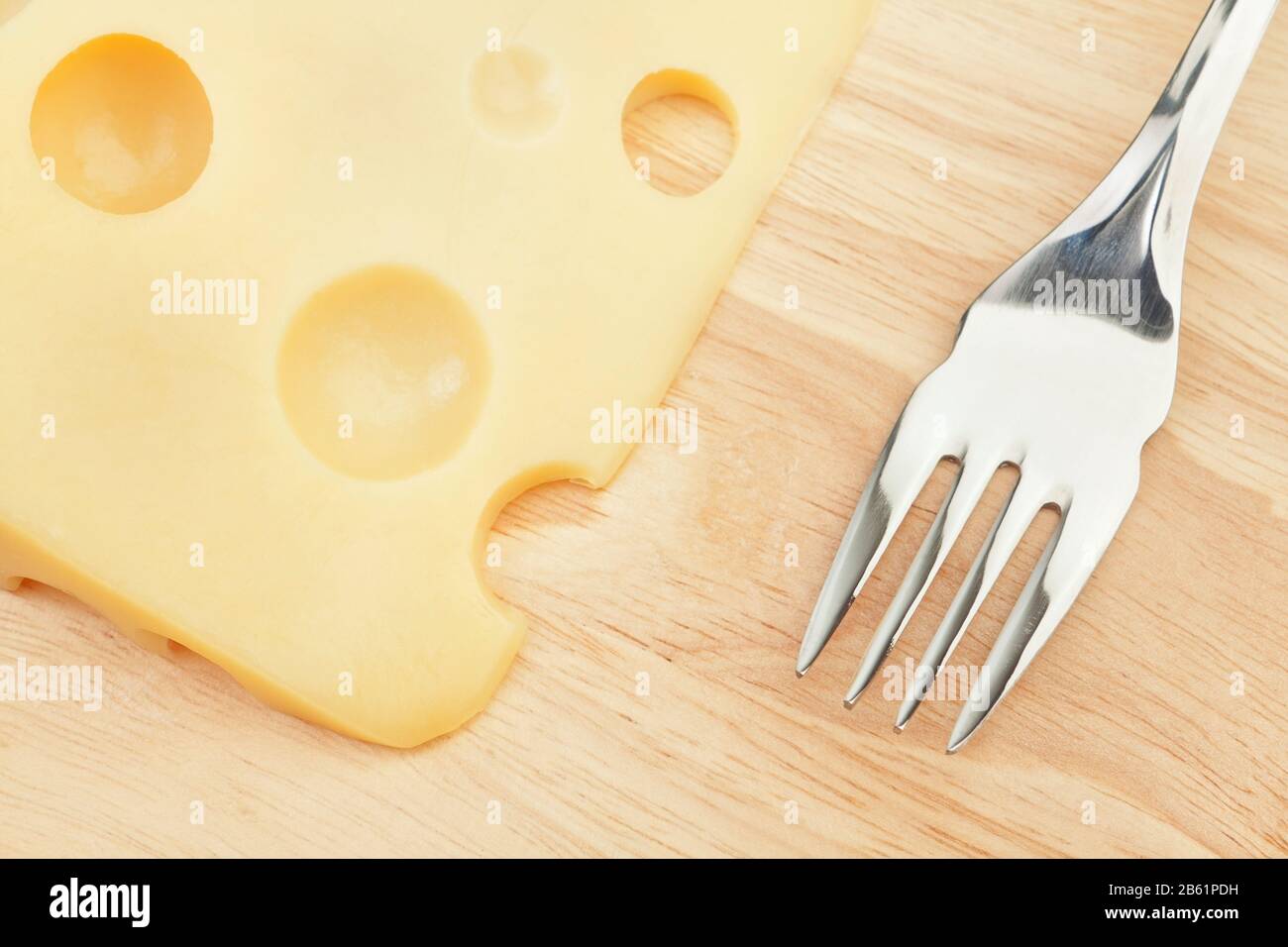 Tasty-grade cheese on a board with a fork. Concept Stock Photo - Alamy