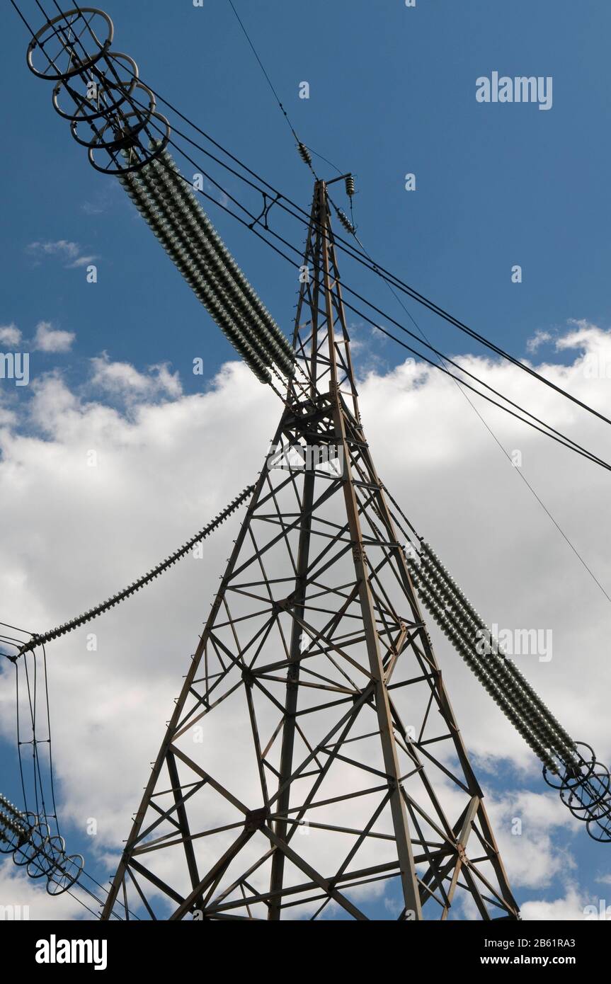 High-voltage power line pylon against blue sky and white cloud ...