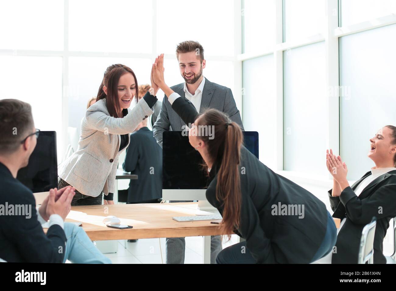 young employees giving each other a high five Stock Photo - Alamy
