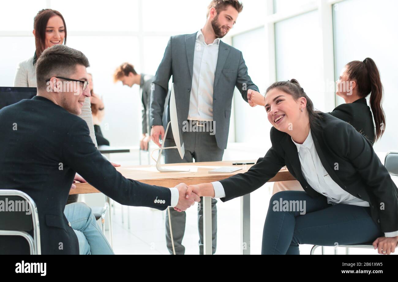 happy employees shaking hands in the workplace Stock Photo - Alamy