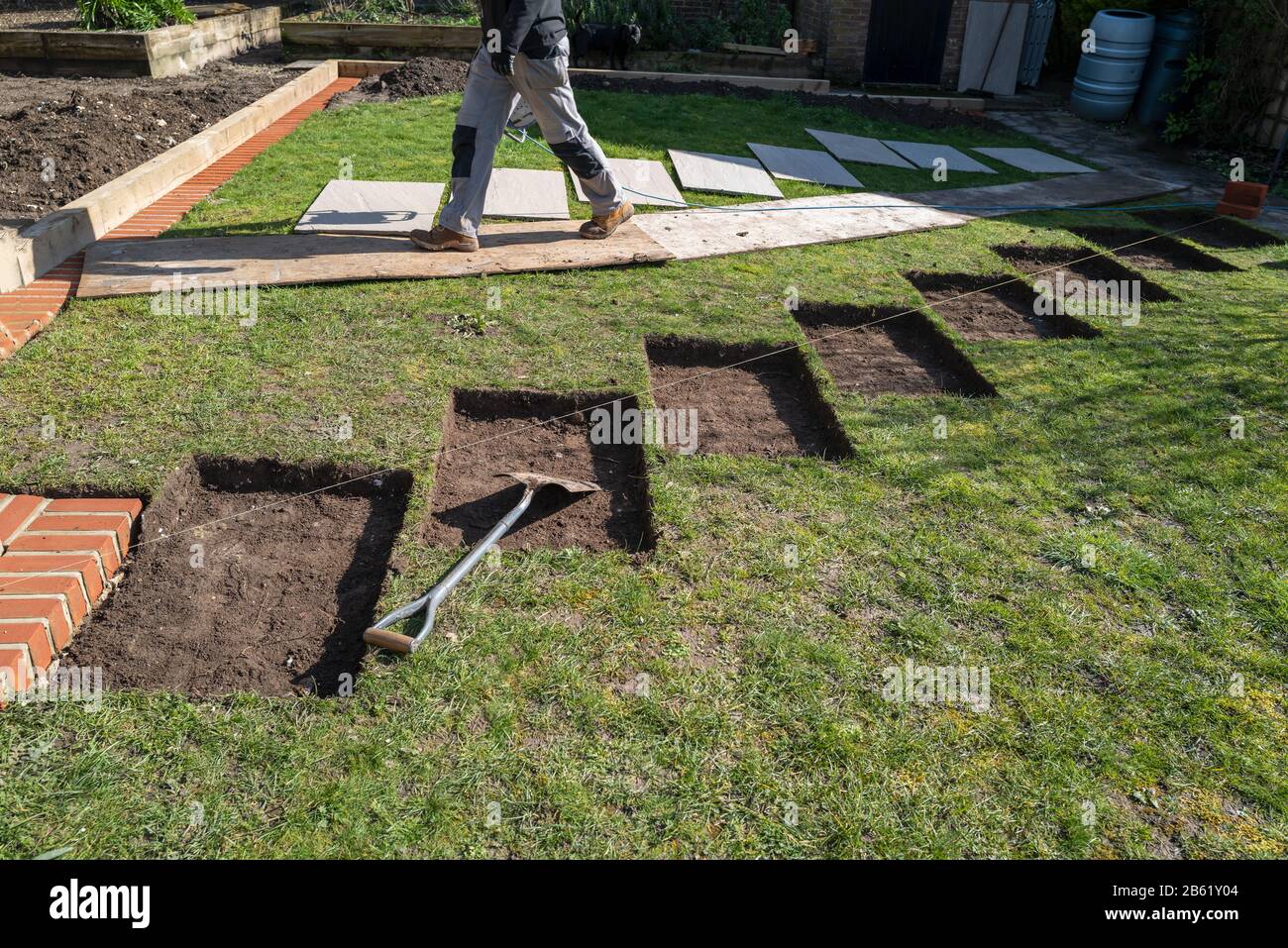 Rectangular sections cut into a lawn in preparation for concrete base ...