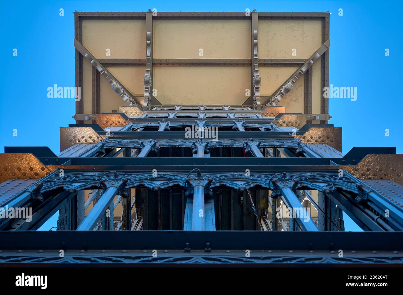 side detail of a view from below of the structure of a metal tower with ...