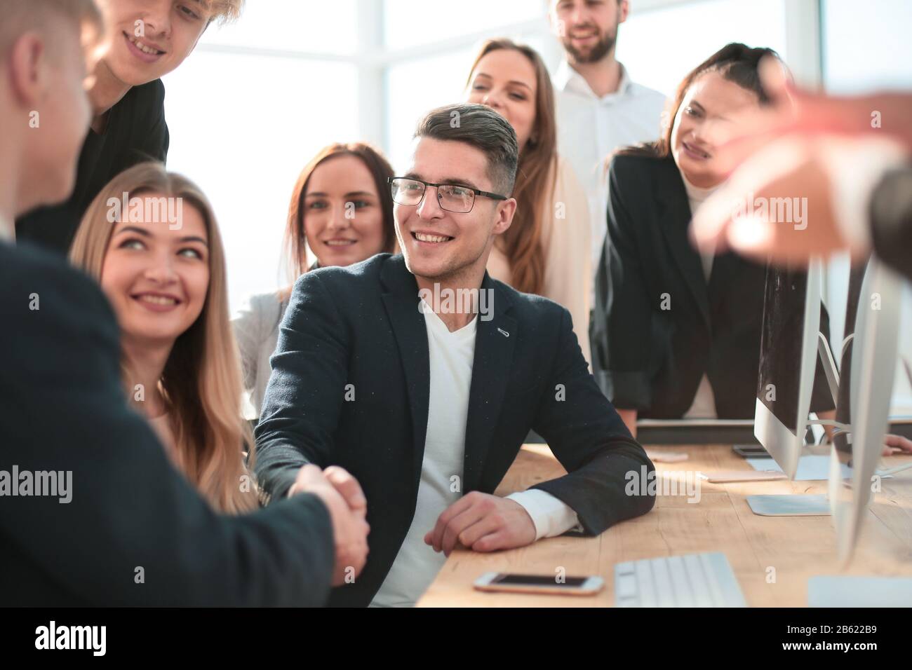 Manager congratulating a young employee in the workplace Stock Photo ...
