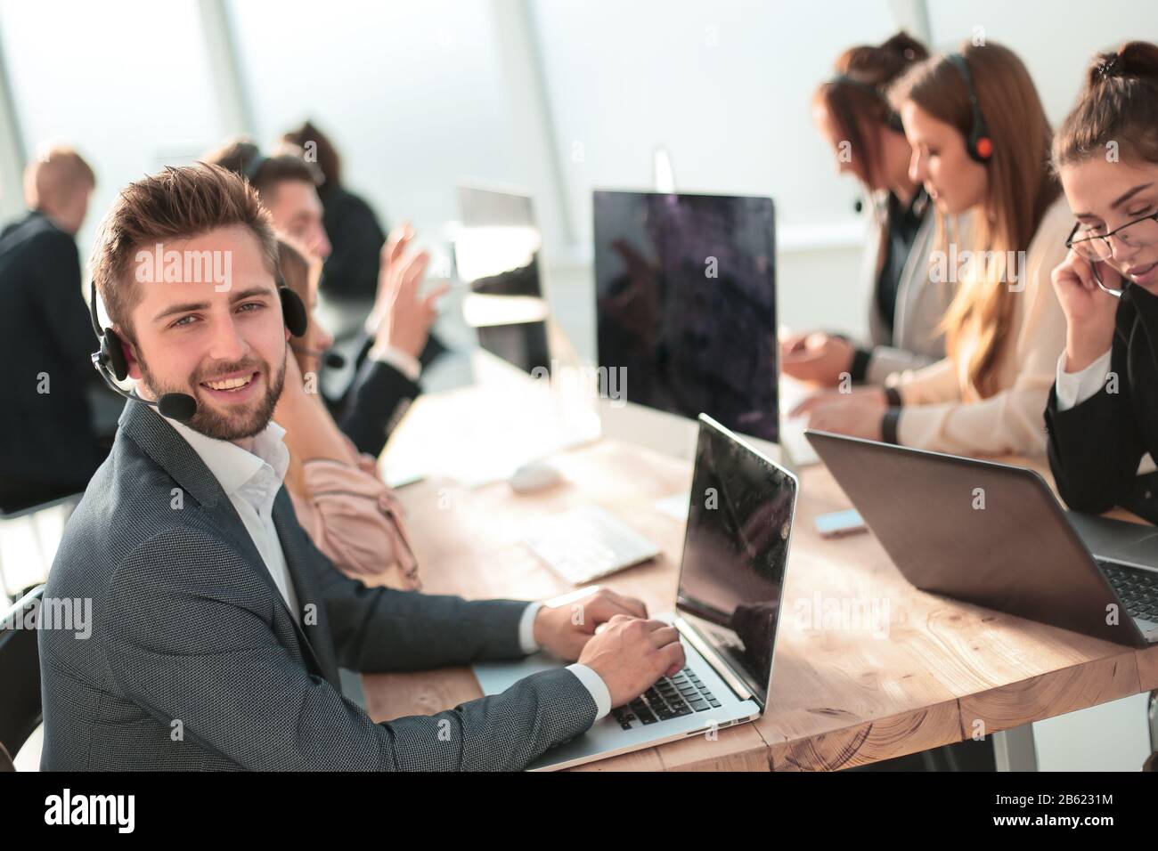 young customer service representative sitting behind a Desk Stock Photo ...