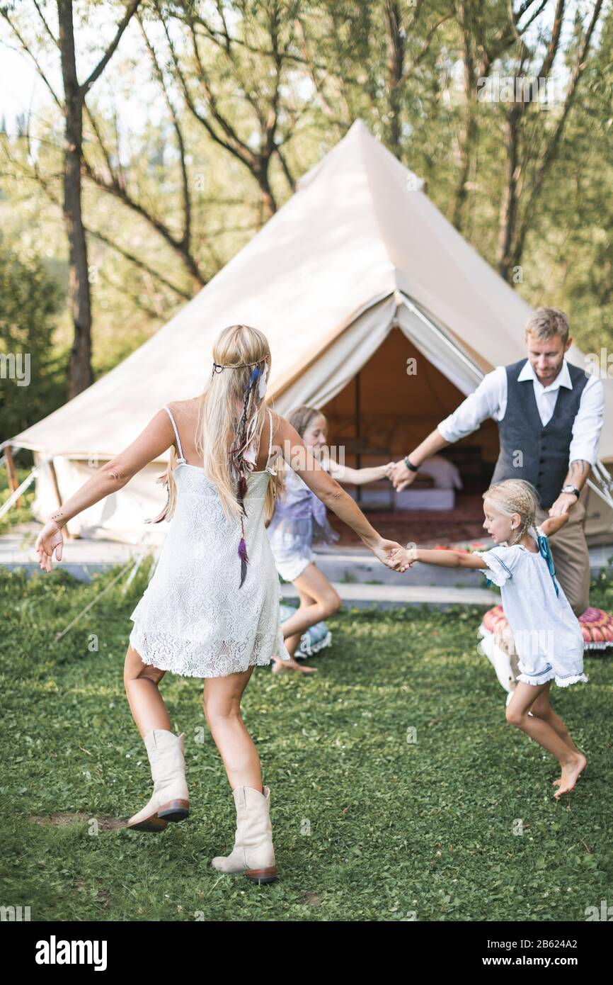 Happy active family wearing stylish boho casual clothes, dancing and ...