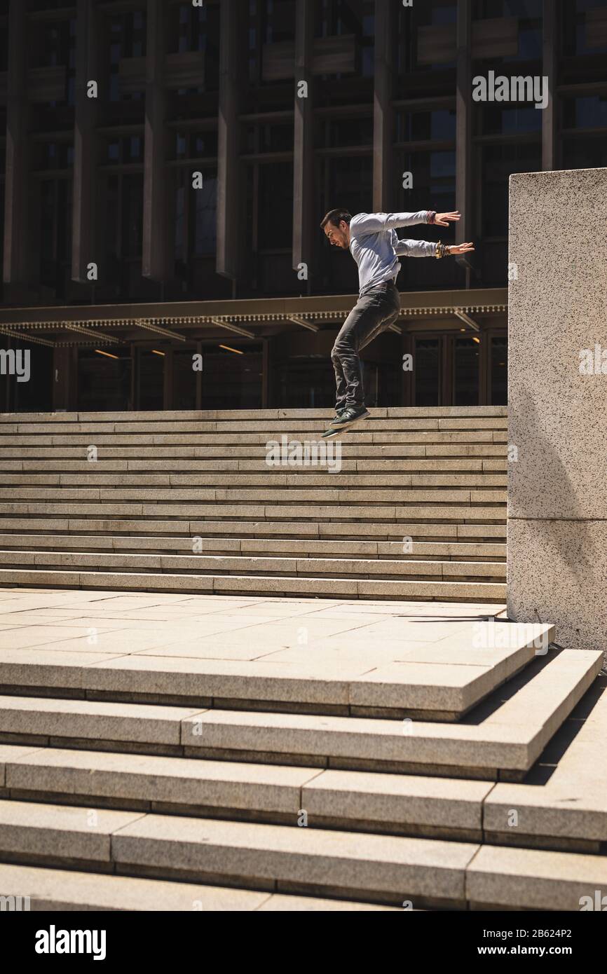 Caucasian man jumping from wall Stock Photo - Alamy