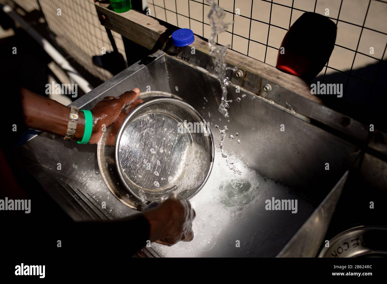 Volunteer washing a bowl Stock Photo - Alamy