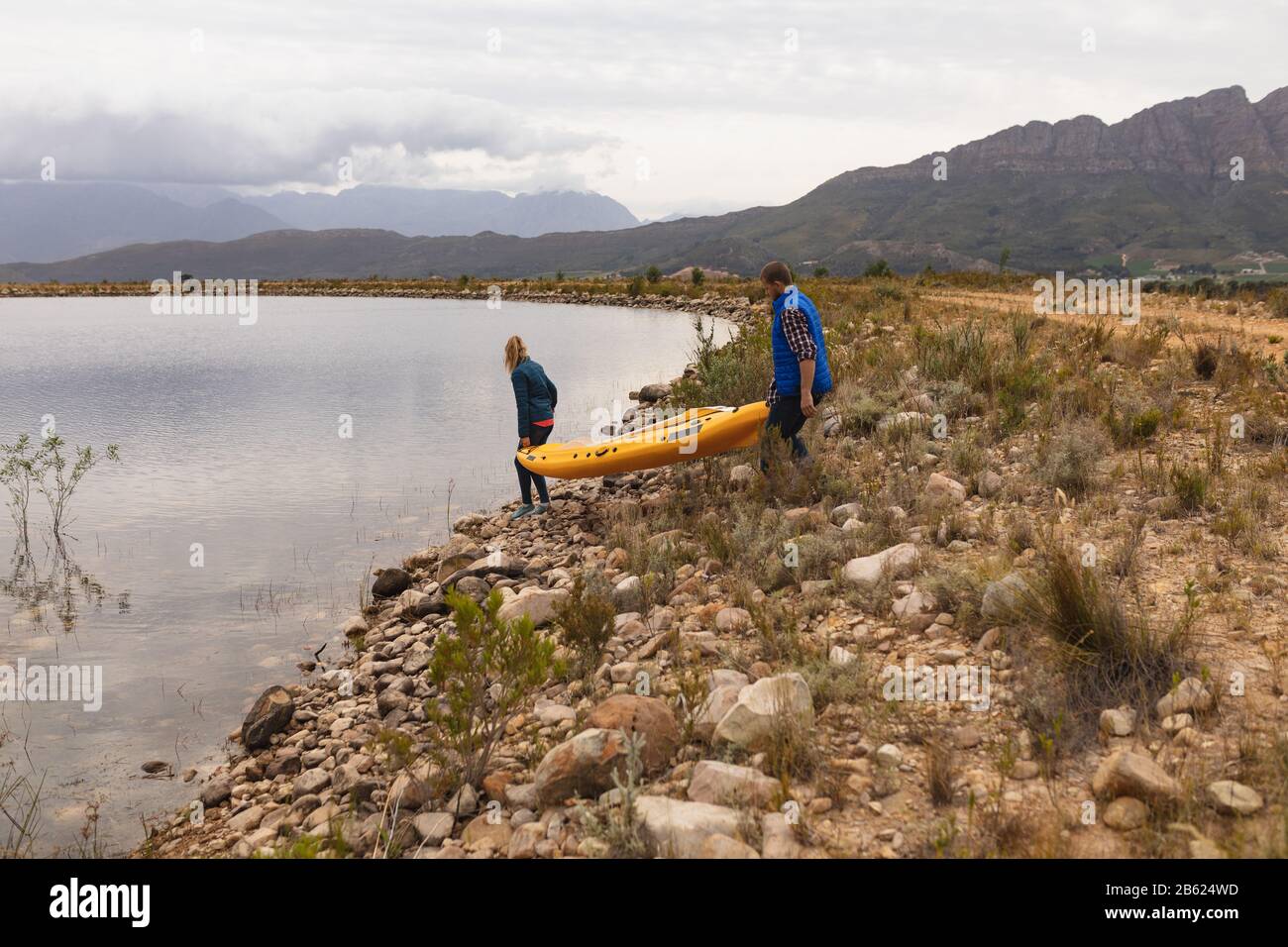 Caucasian couple holding a kayak Stock Photo - Alamy