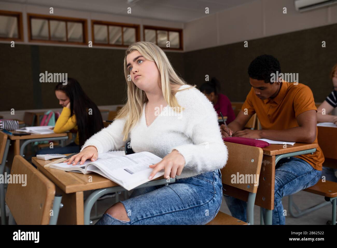 Side view of students working in class Stock Photo - Alamy