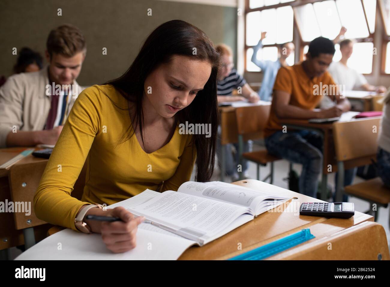 Side view of students working in class Stock Photo - Alamy