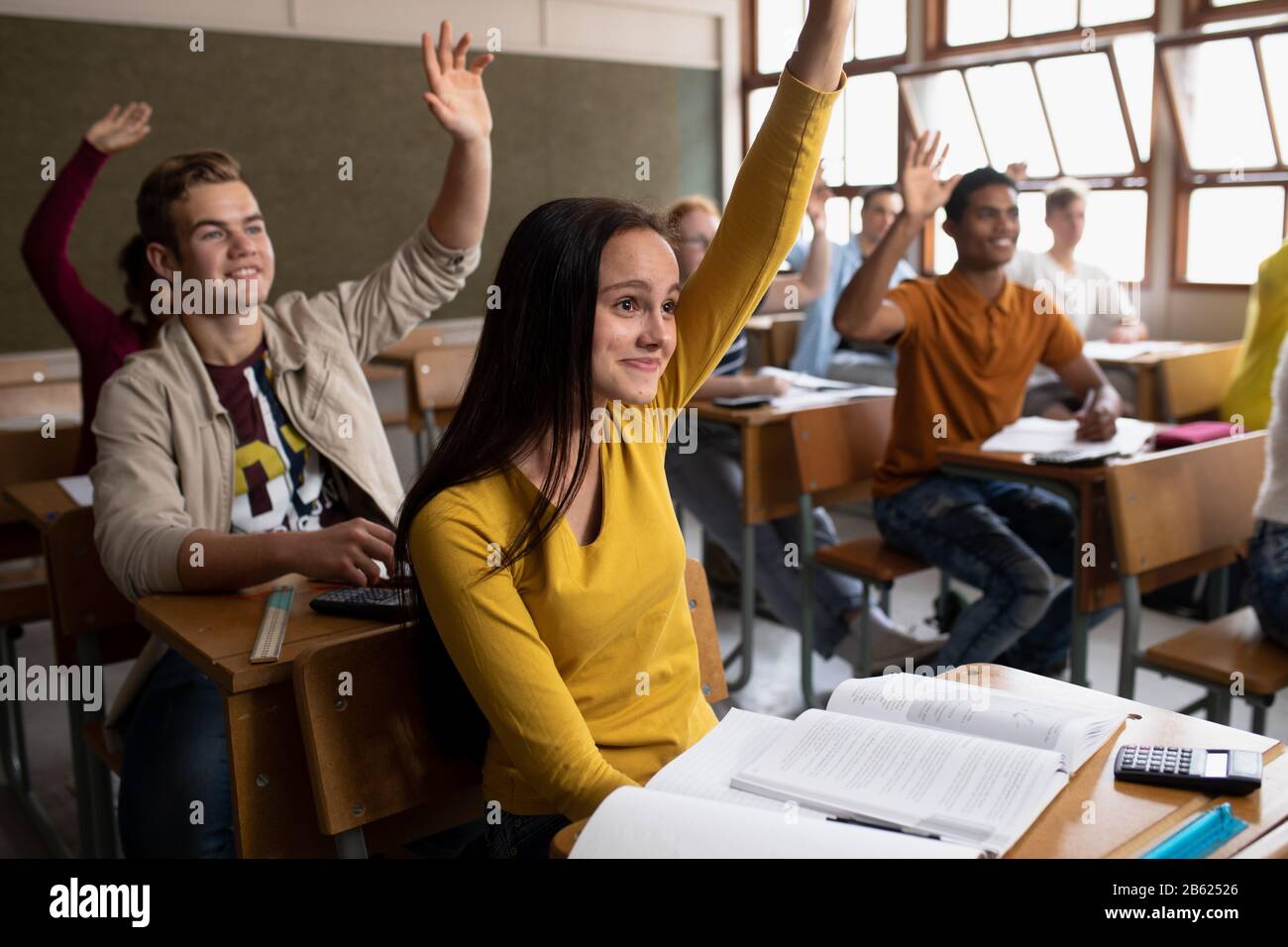 Classroom raising their hands hi-res stock photography and images - Alamy