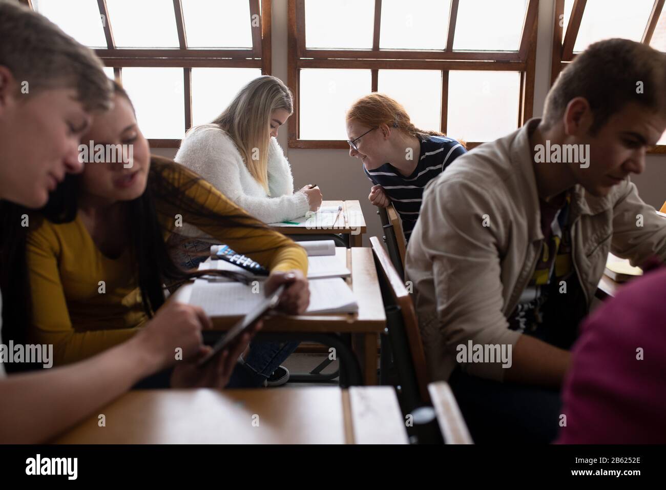 Side view of students talking in class Stock Photo - Alamy