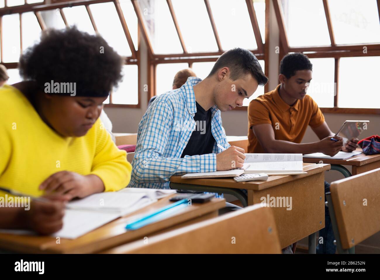 Side view of students working in class Stock Photo - Alamy