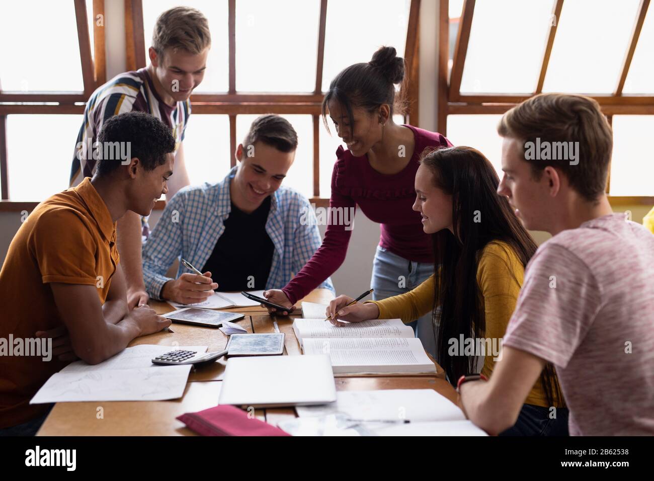 Front view of students working together in group Stock Photo - Alamy