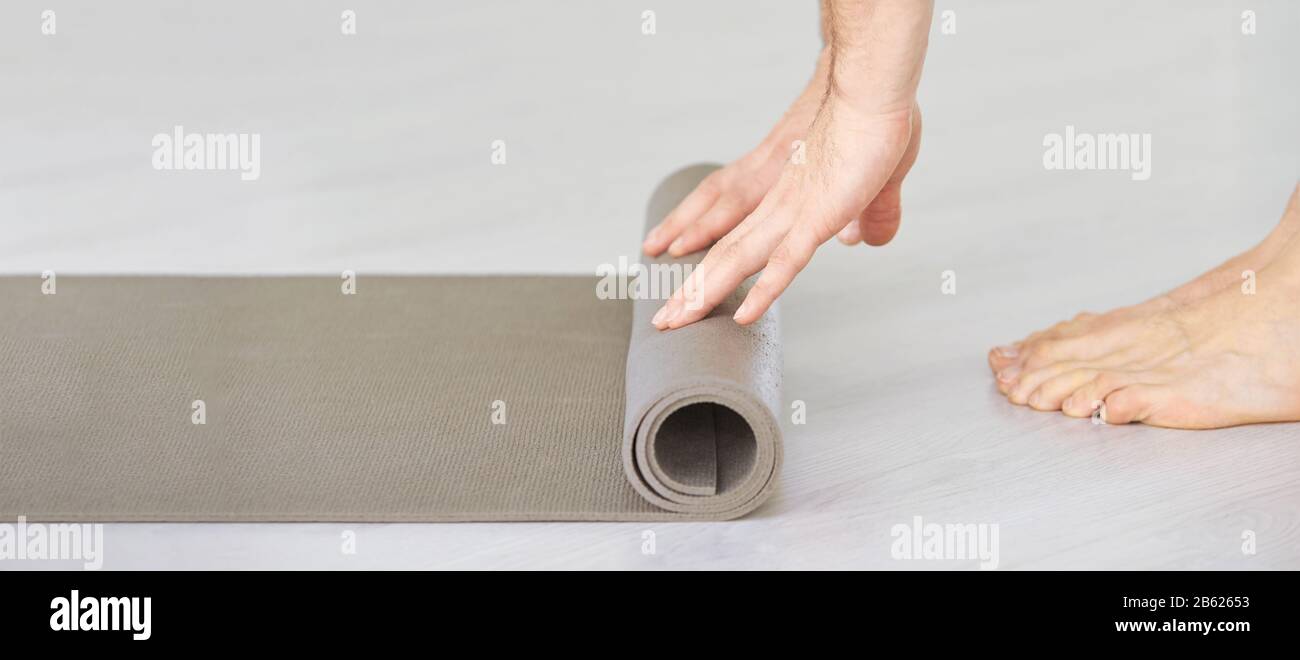 Yoga person rolling sport mat. Grey color. Gym carpet Stock Photo - Alamy