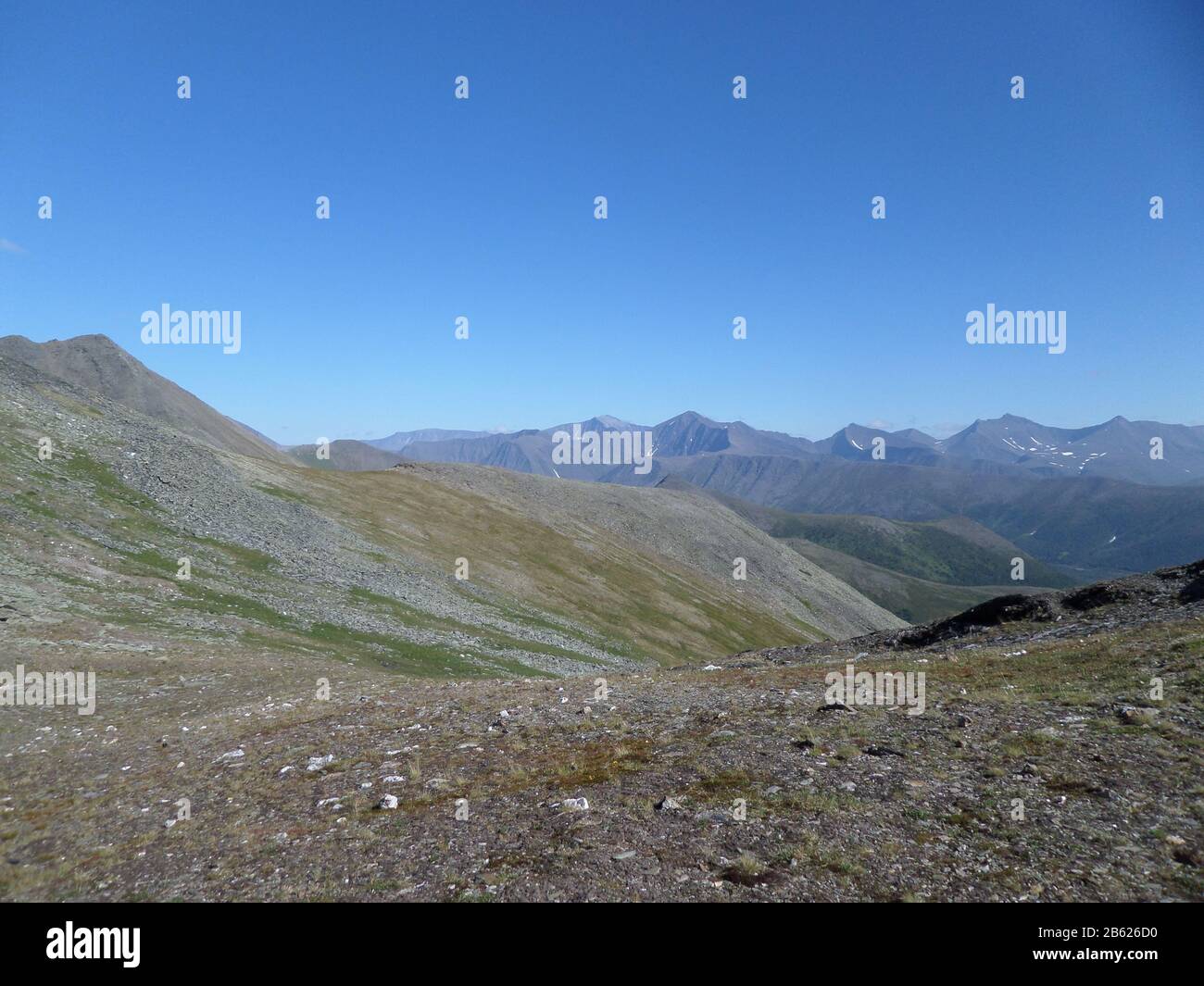 Mountain landscape with peaks, valleys, green grass, rocks and gray ...